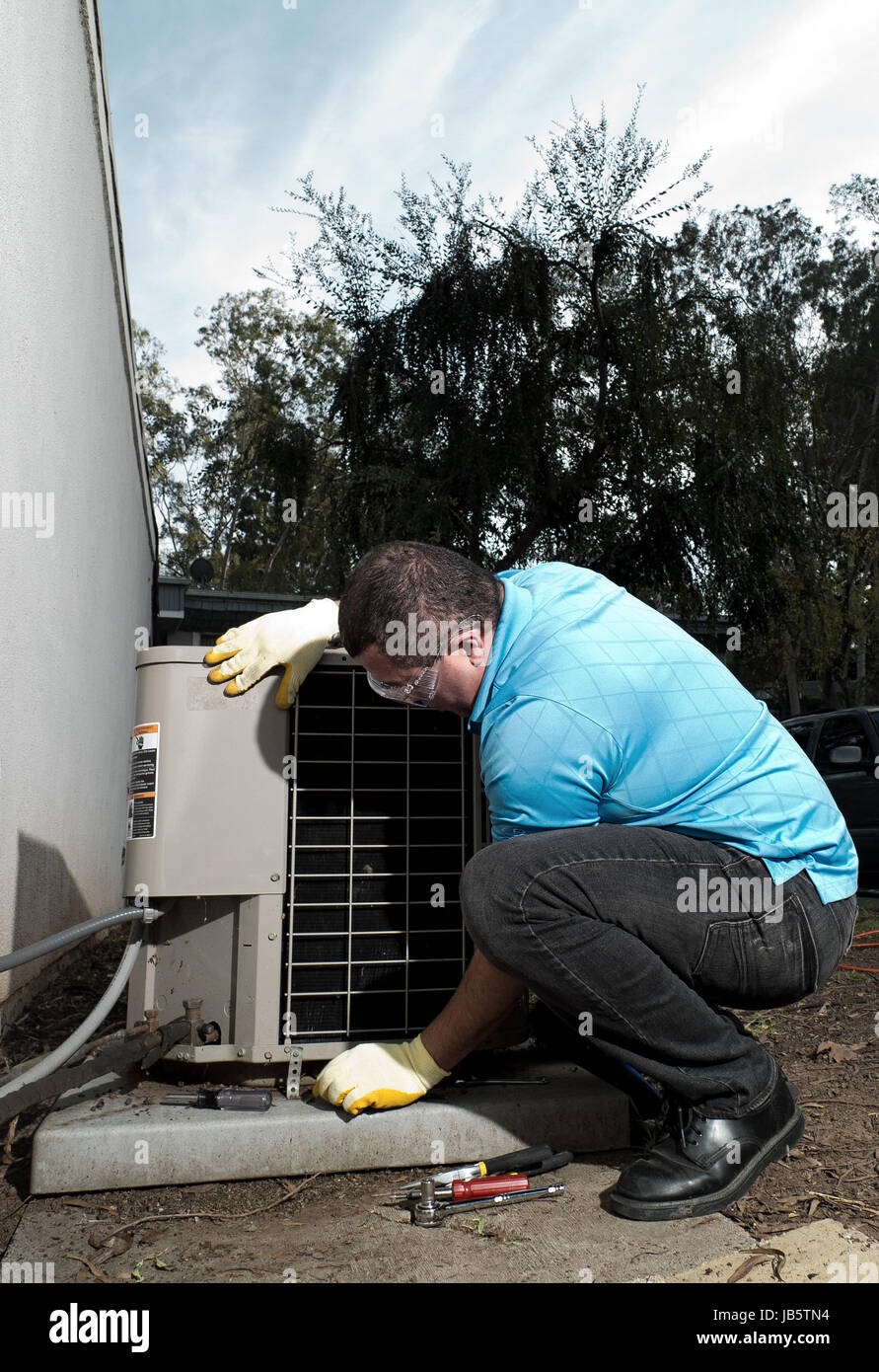 Hispanic air conditioning system repair maintenance man Stock Photo - Alamy