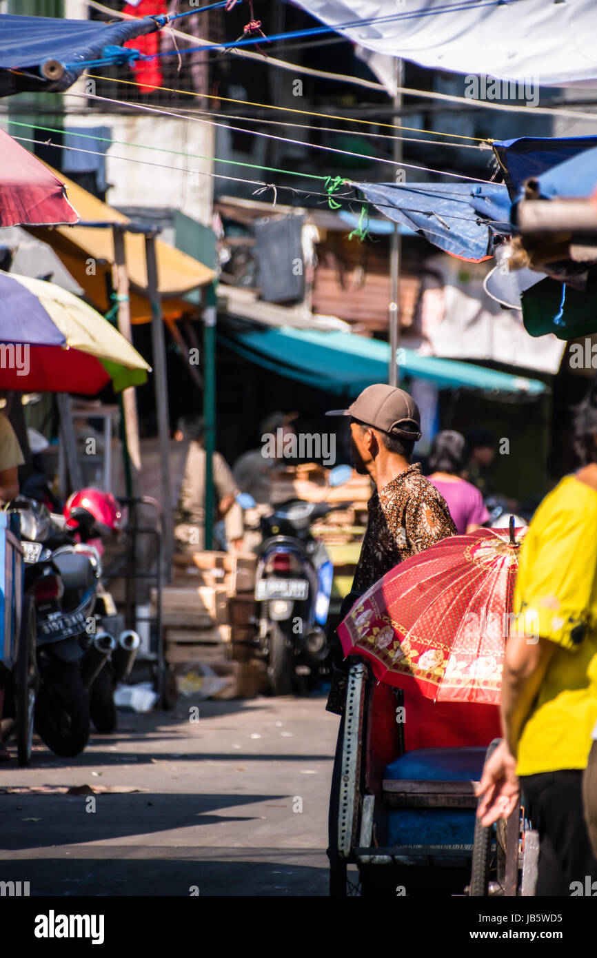 A pedicab worker waiting in the traditional market to serve a customer ...