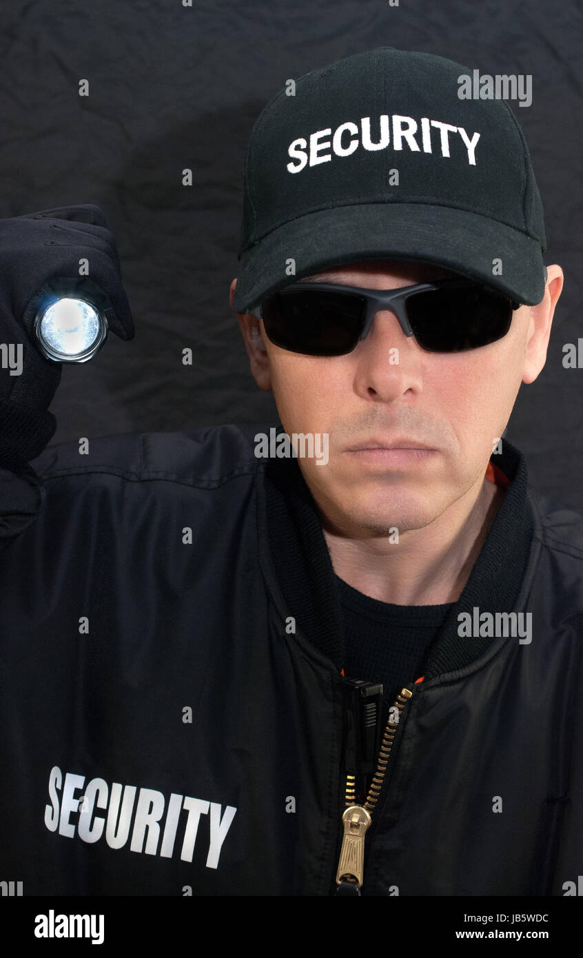 Close-up of a security guard shining a flashlight at the camera Stock ...