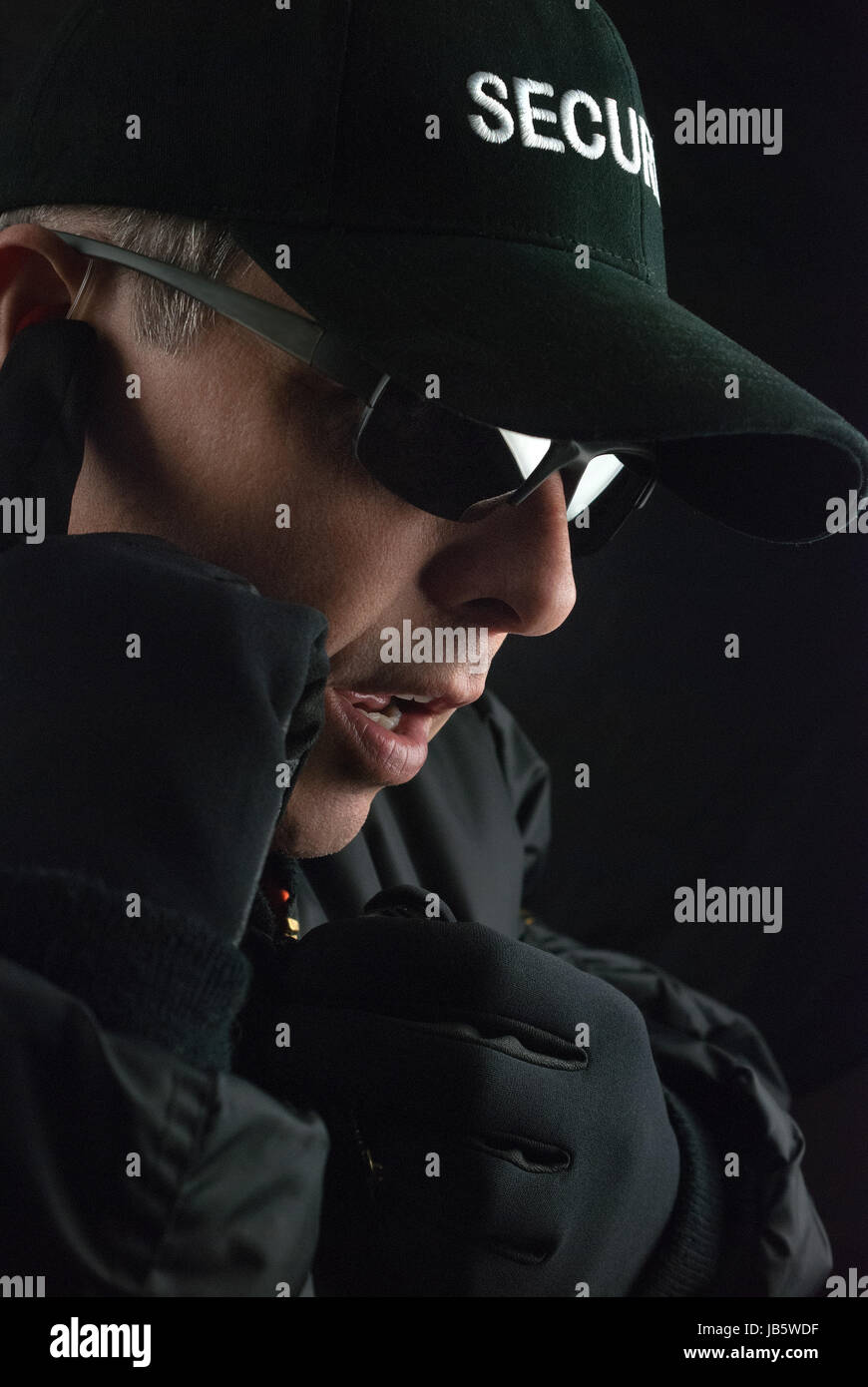 Close-up of a security guard reporting the situation into his ...