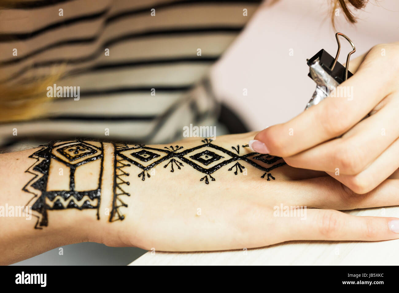 Drawing process of henna menhdi ornament on woman's hand Stock Photo ...