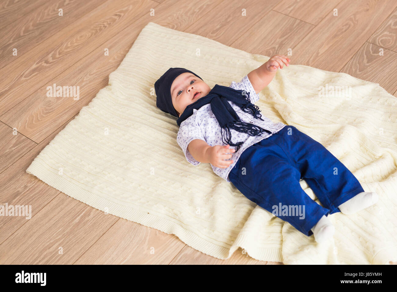 Portrait of a little adorable newborn infant baby boy lying on back on ...