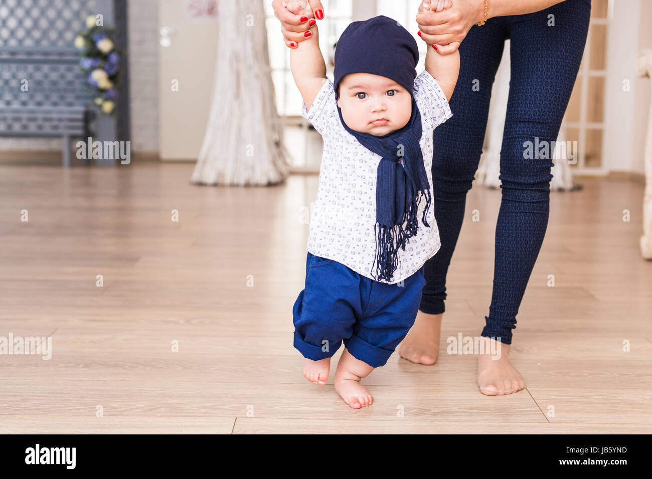 baby taking first steps with mother help Stock Photo - Alamy