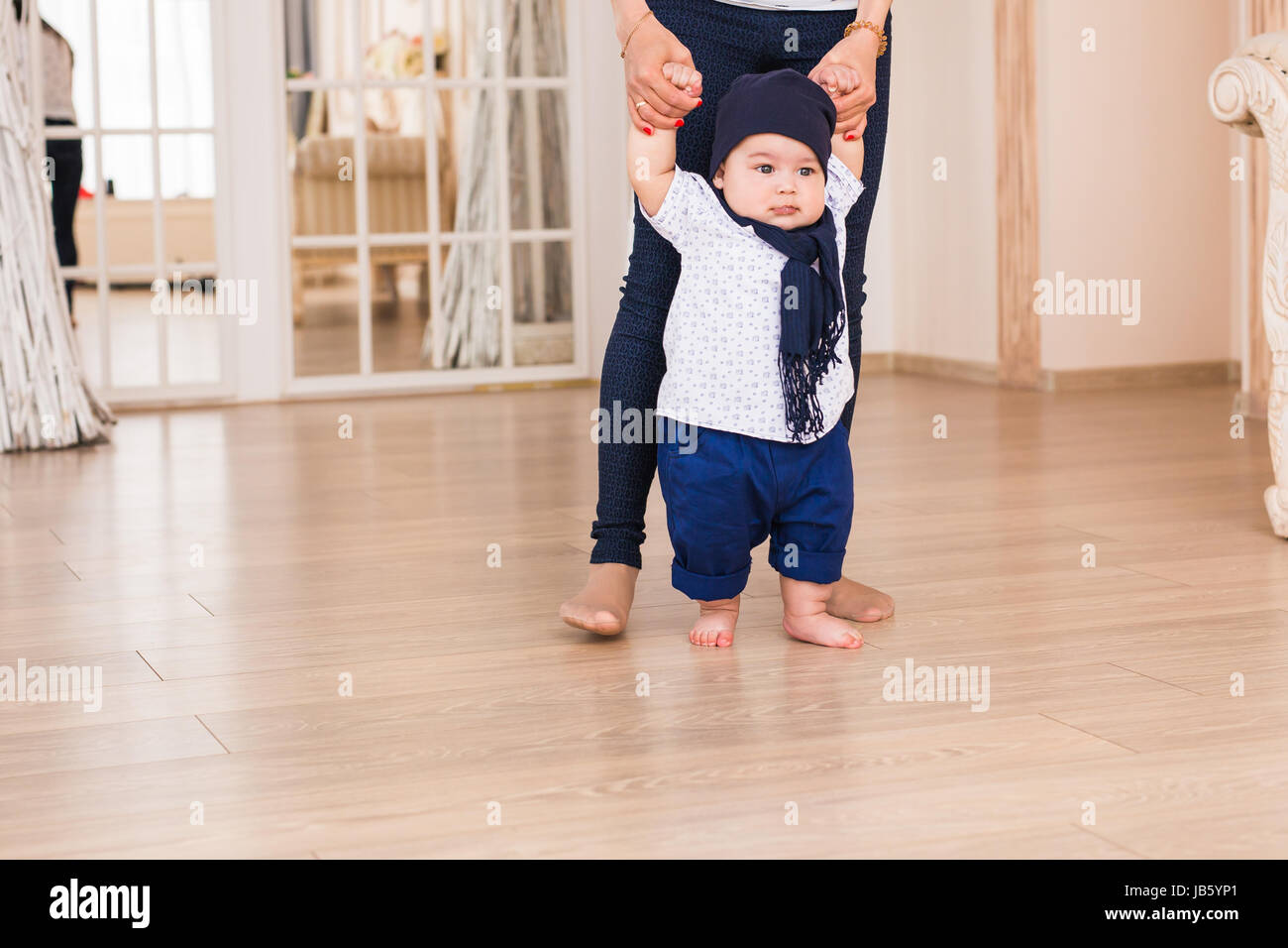 baby taking first steps with mother help Stock Photo - Alamy
