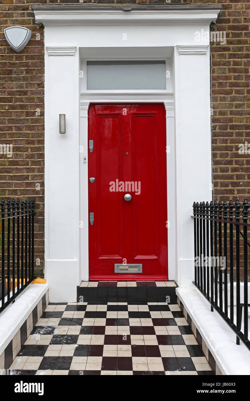 Red entrance door on residential house with brick facade Stock Photo ...