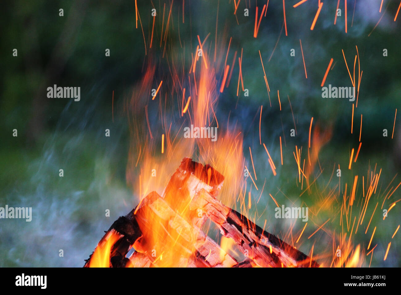 Beautiful evening fire with flying sparks against the background of ...