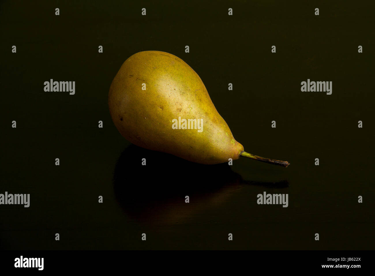 Fruits - single pear laying on dark table with reflection Stock Photo ...