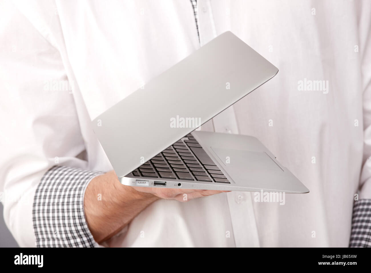 Hand holding a laptop Stock Photo - Alamy