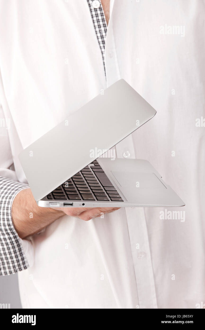 Hand holding a laptop Stock Photo - Alamy