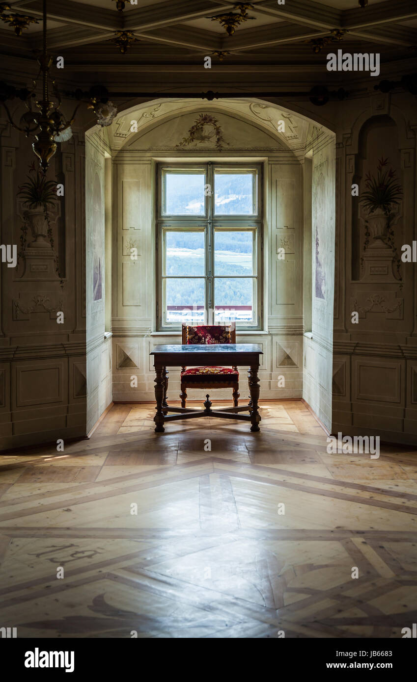 A solitaire chair and table in an ampty room of Castle Savoia, building ...