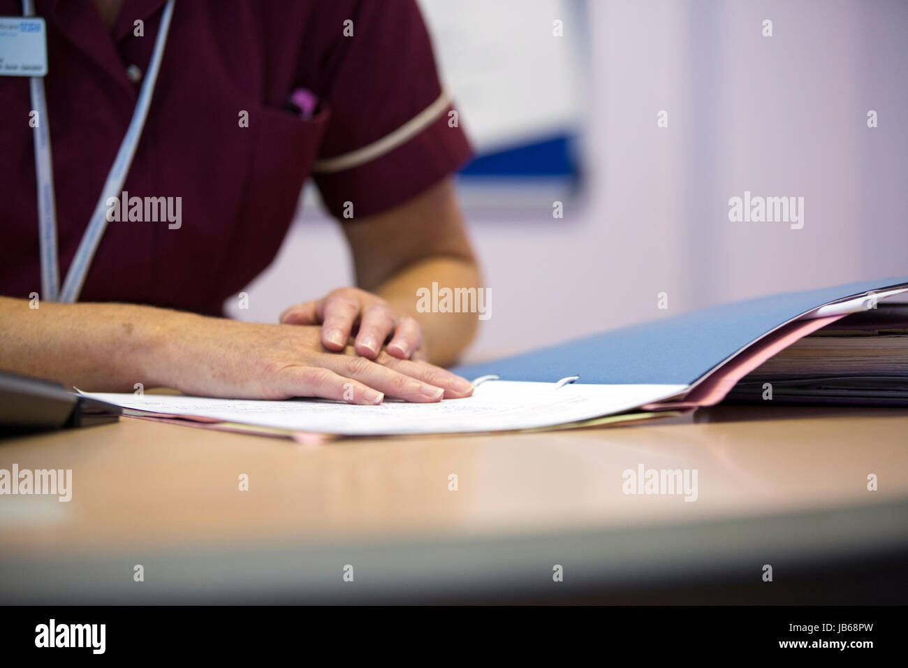 nurse working at desk with notes Stock Photo - Alamy