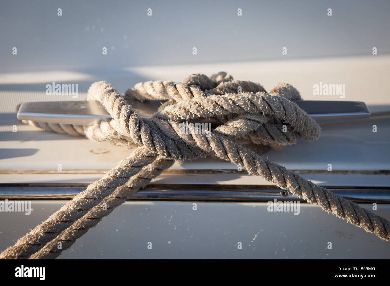 White mooring rope tied around steel anchor on a sailing boat or ship ...