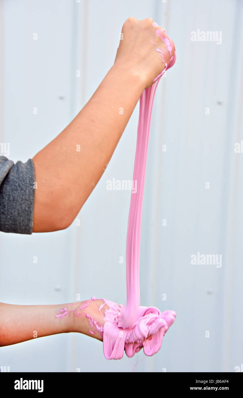young girl playing with pink slime Stock Photo - Alamy