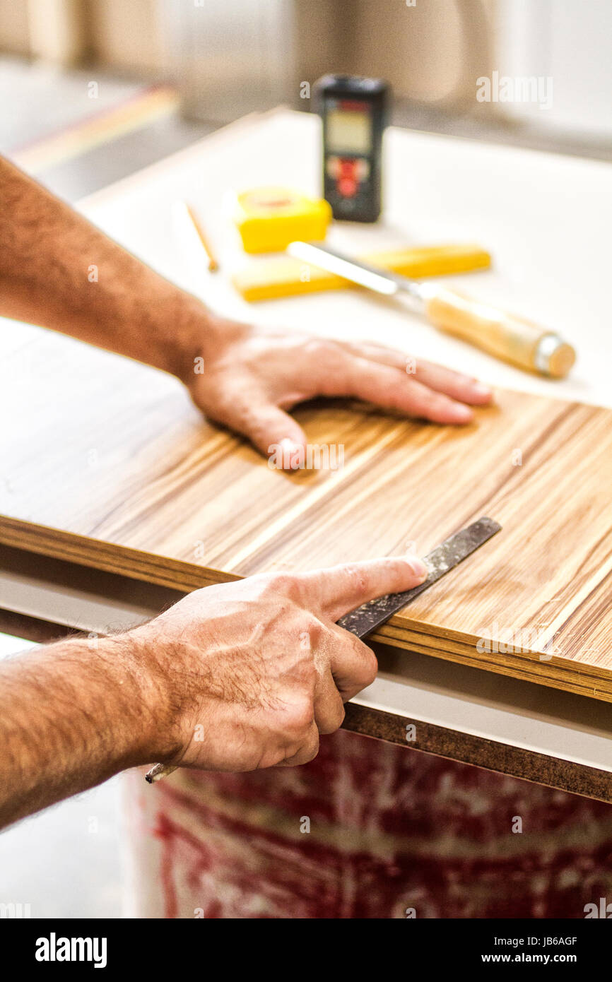 Hands of a joiner working on the finishing of a MDF timber in a joinery ...