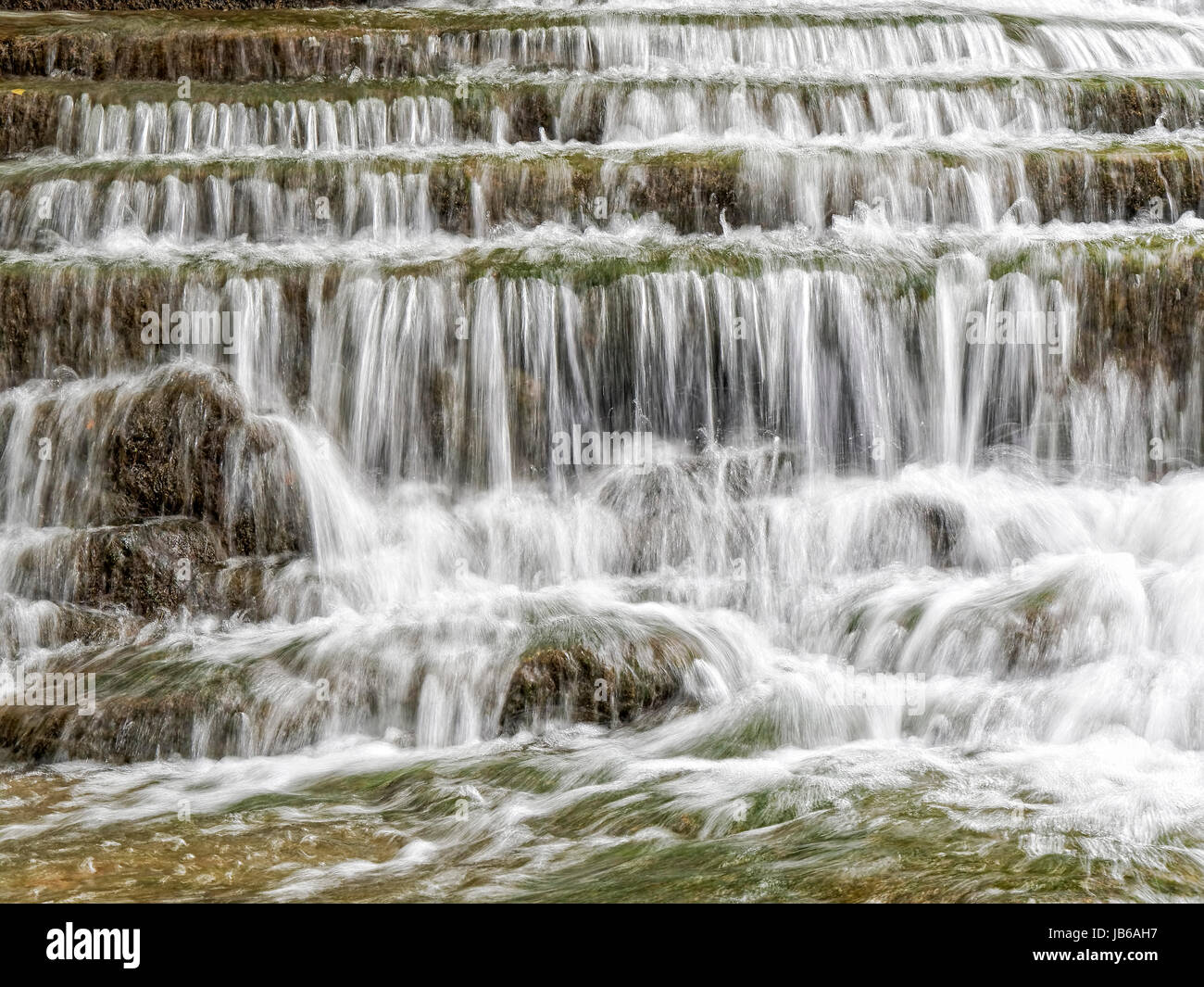 Close up of a waterfall created by river water pouring over a series of ...