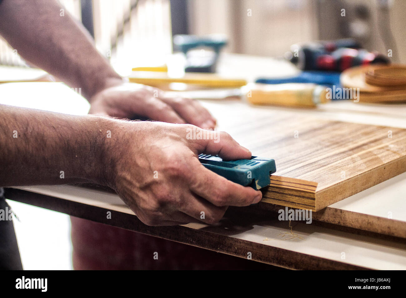 Hands of a joiner working on the finishing of a MDF timber in a joinery ...