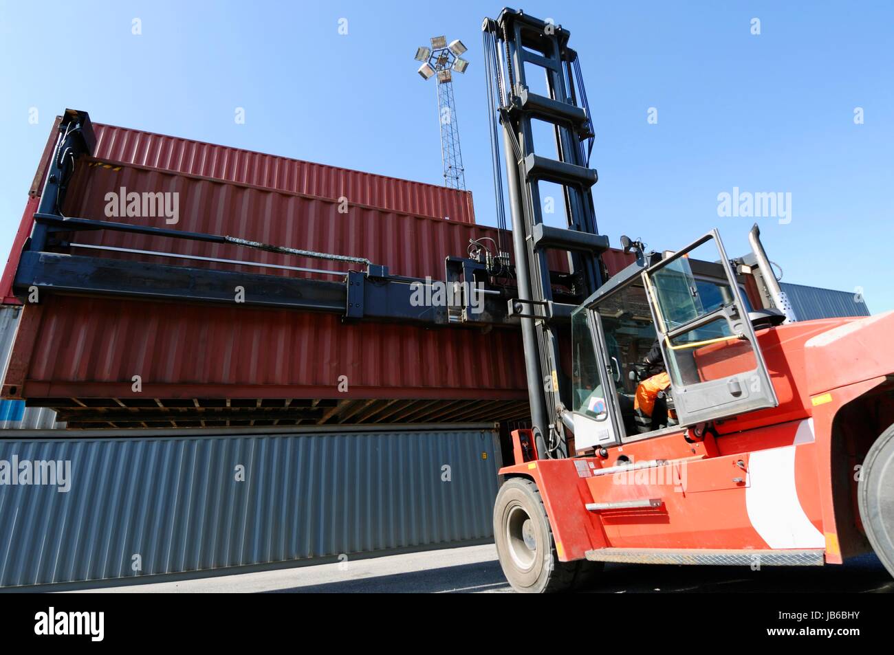 Forklift truck lifting shipping container Stock Photo - Alamy