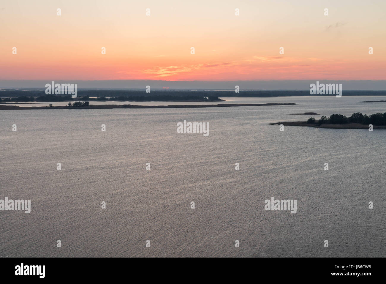 The beginning of the sun rising above the river. The sun is in the ...