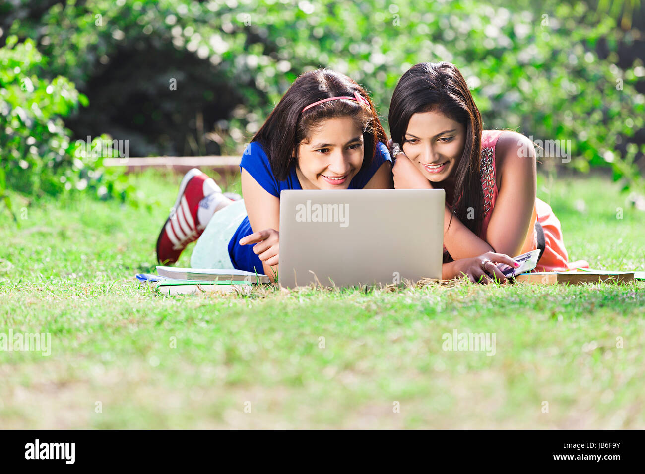 2 Indian College Girls Students Using laptop Studying In Park Stock ...