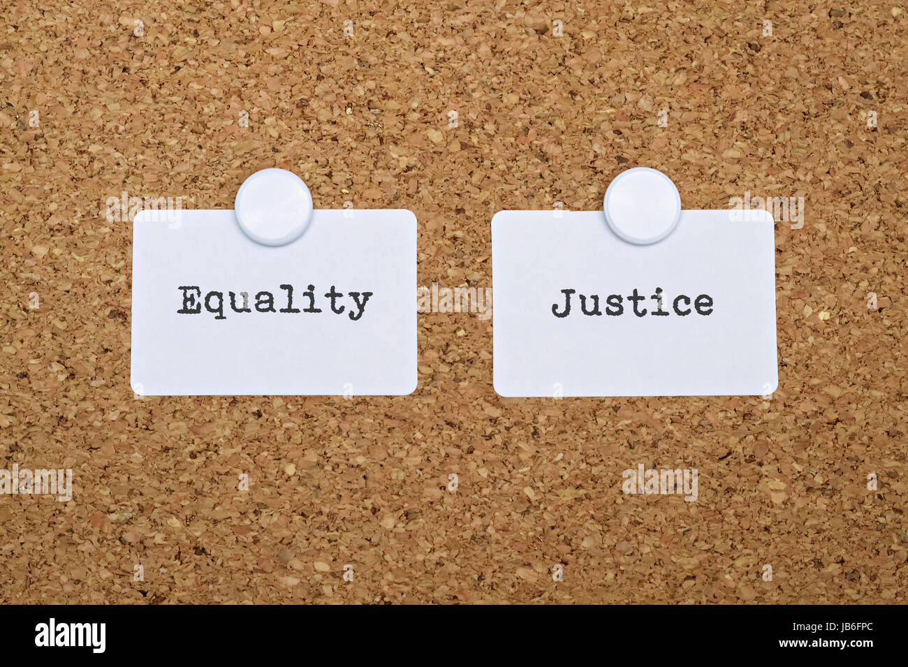 Words Equality and Justice written on two white stickers pinned on cork ...