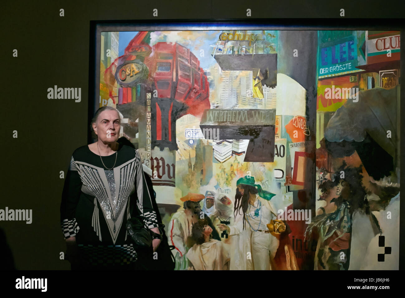 Artist Maija Tabaka sits in front of her picture 'Ka Tevi sauc?' (lit ...