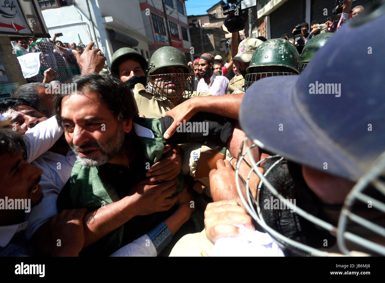 Srinagar, Kashmir. 9th Jun, 2017. Indian policemen try to detain ...