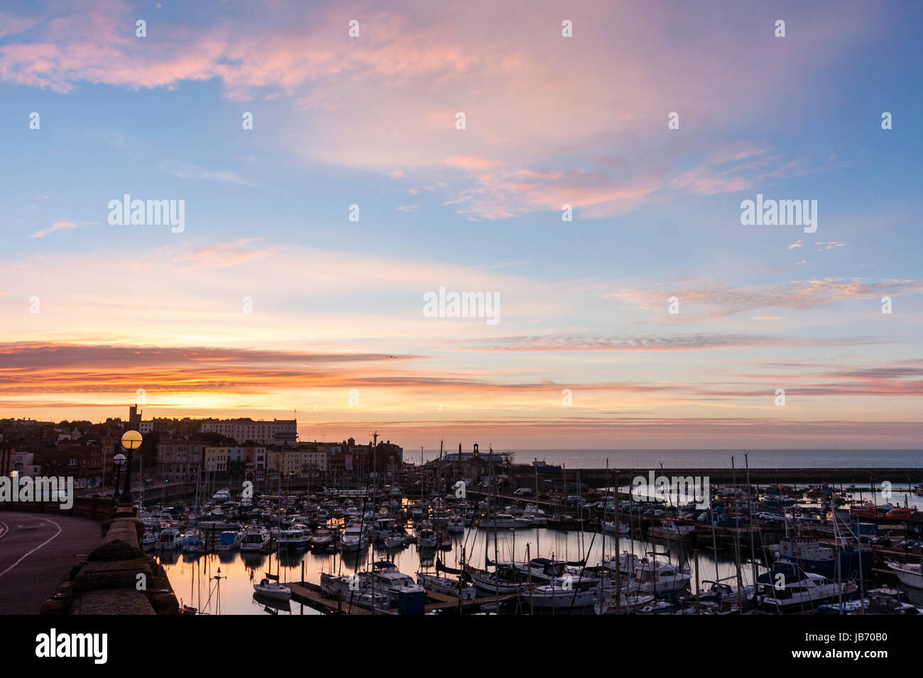 Dawn sky over Ramsgate town and the harbour. Sky blue to orange. Left ...
