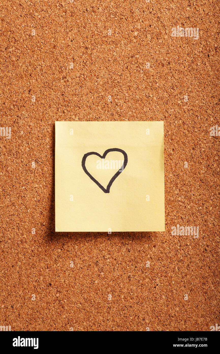 Color shot of a cork board with a sticky note and a hear-shaped drawing ...