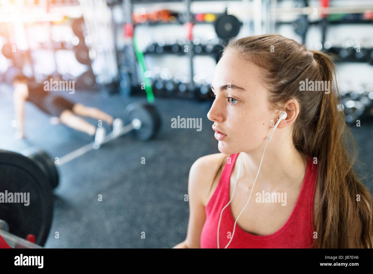Young woman in gym, earphones in her ears,listening music Stock Photo ...