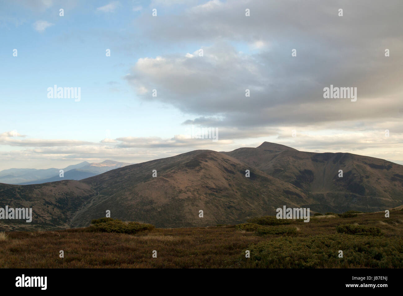 Mountain peaks in the autumn evening sky with clouds Stock Photo - Alamy