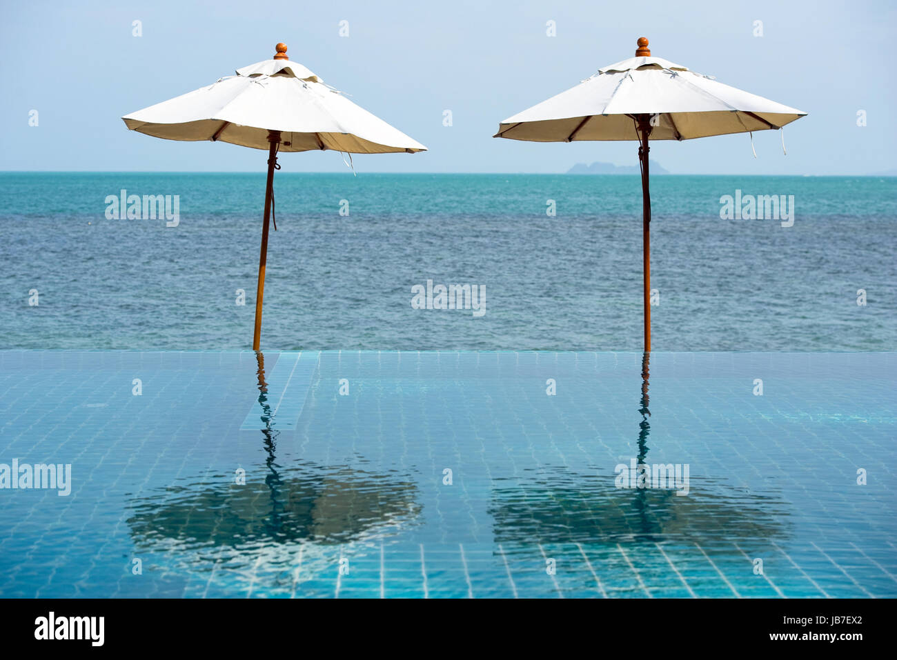 Swimming pool and parasols in a tropical resort Stock Photo - Alamy