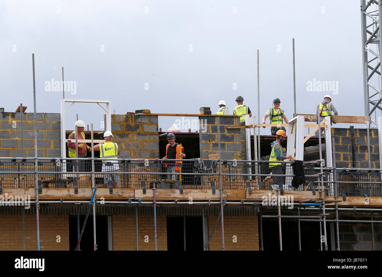 Builders at work on a building site, constructing a new delevlopment of ...