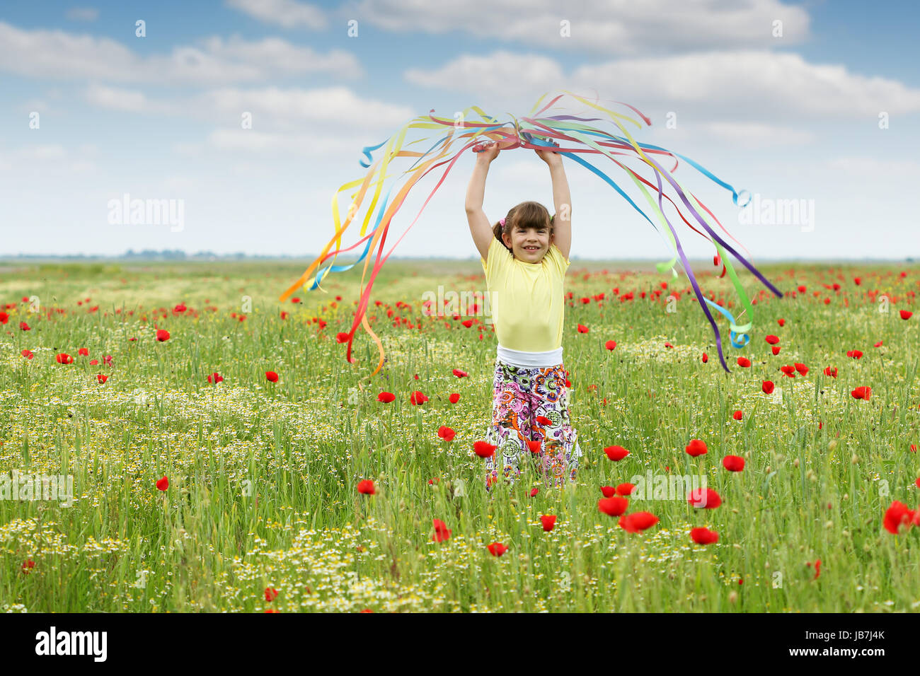 beautiful little girl waving with colorful ribbons on meadow Stock ...
