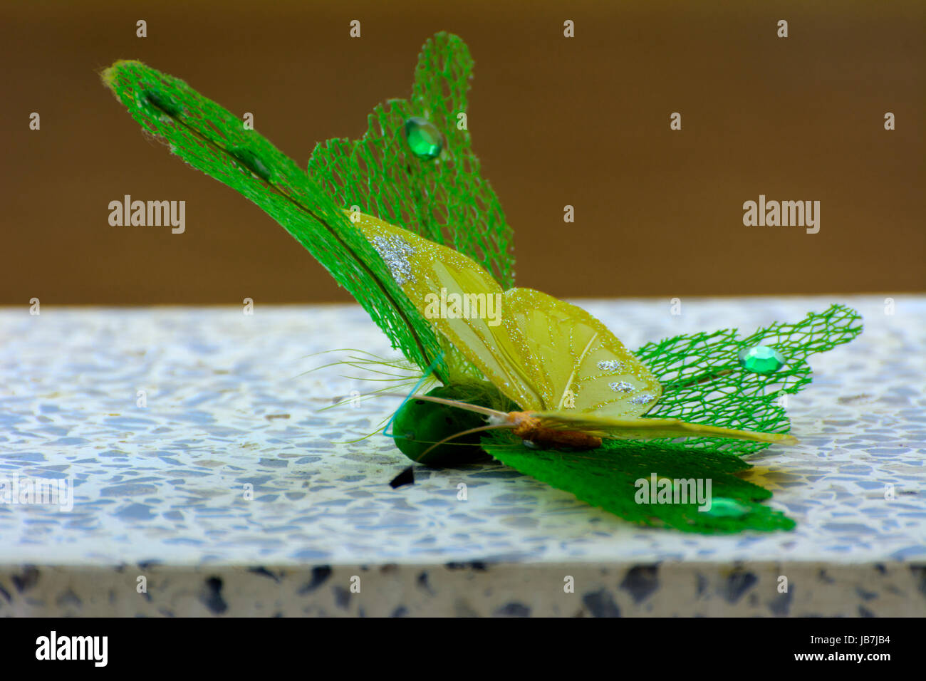 Plastic butterfly figurine on a yellow background Stock Photo - Alamy