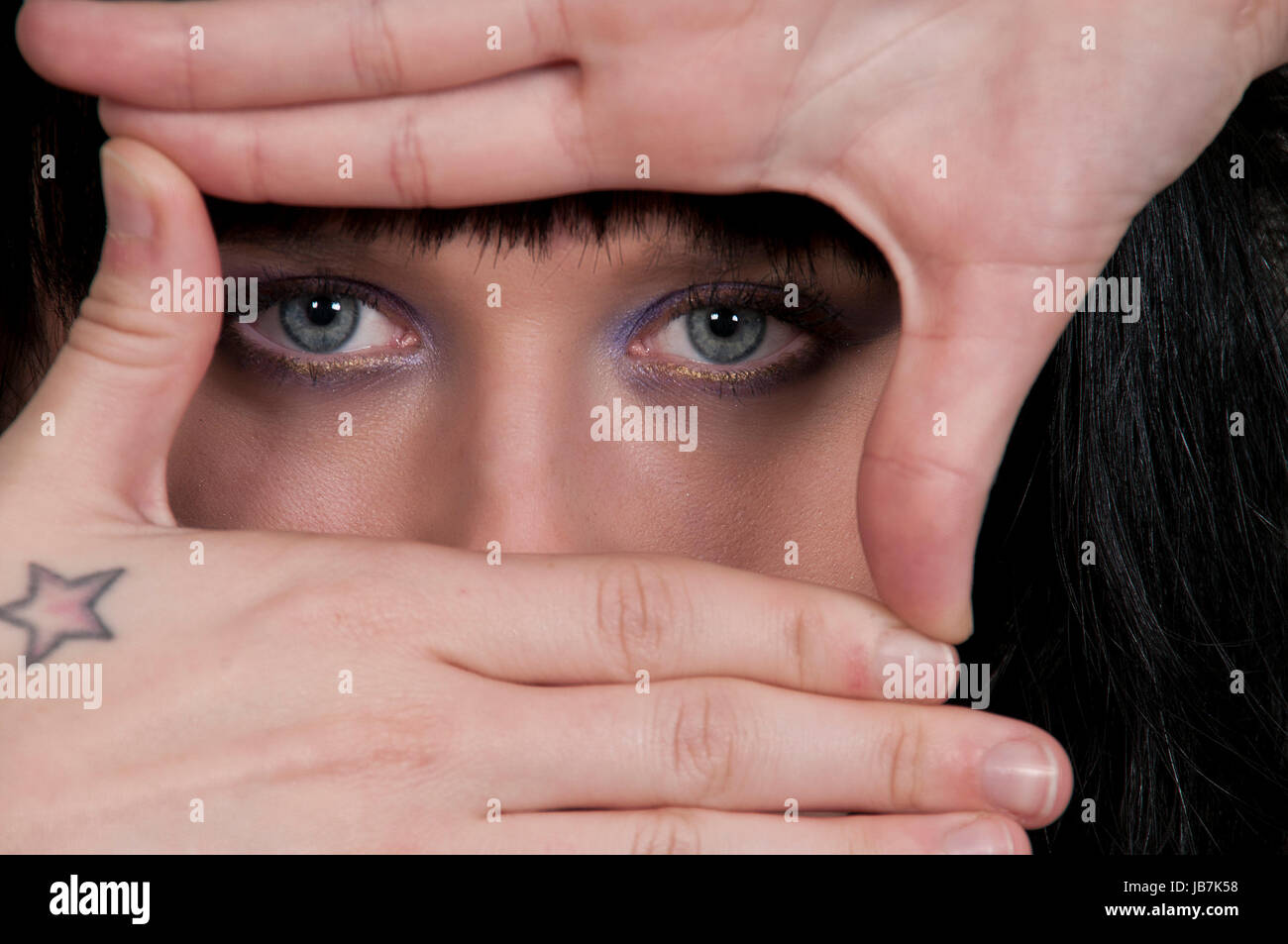 Beautiful young vulnerable scared or surprized woman looking through ...