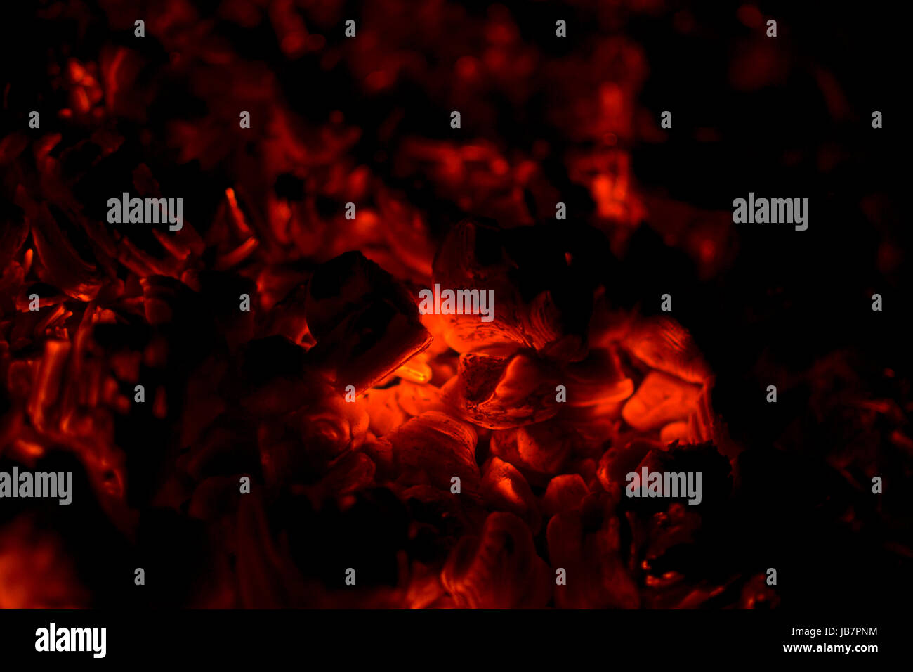 glowing red charcoal close-up on black background Stock Photo - Alamy