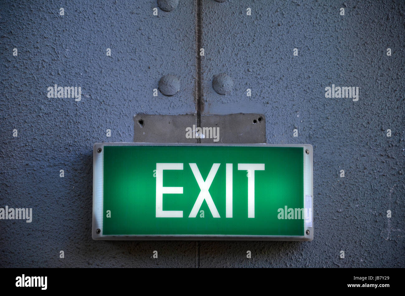 Exit sign points the way out of building Stock Photo - Alamy