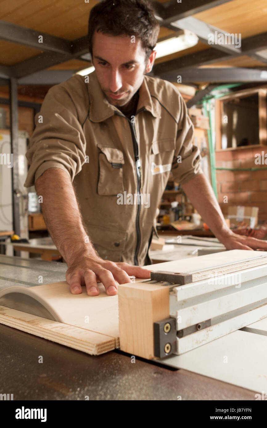 young worker at work in joinery while using a circular saw Stock Photo ...