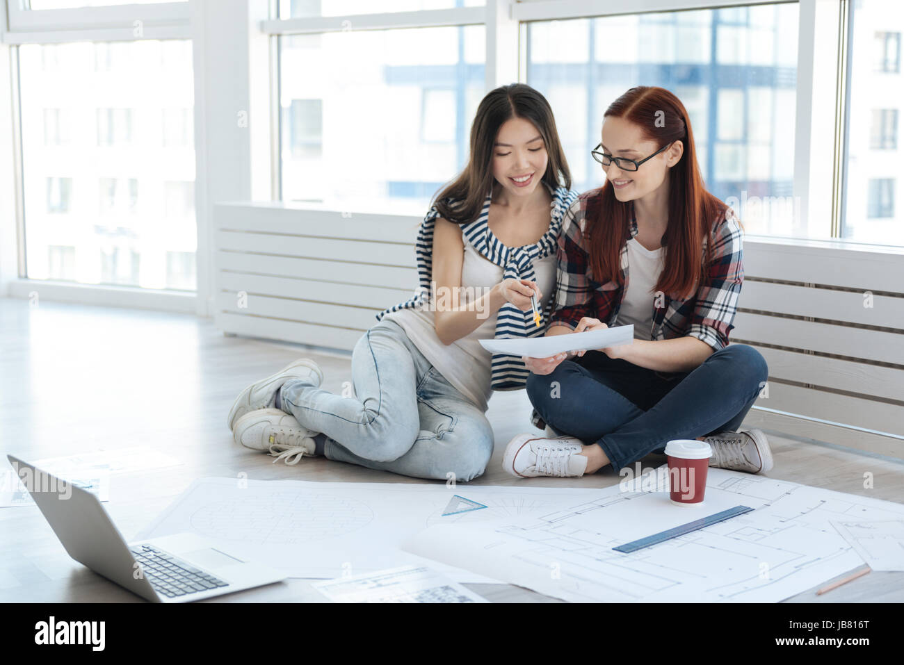 Nice friendly colleagues sitting together Stock Photo - Alamy