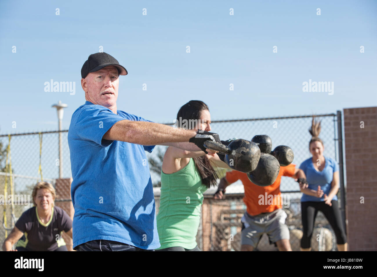 Mature male lifting kettle bell weights in outdoor class Stock Photo ...