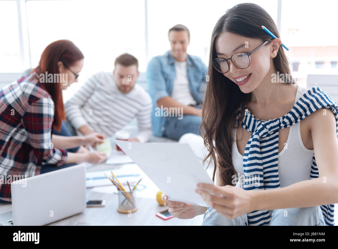 Cheerful hard working woman reading a document Stock Photo - Alamy
