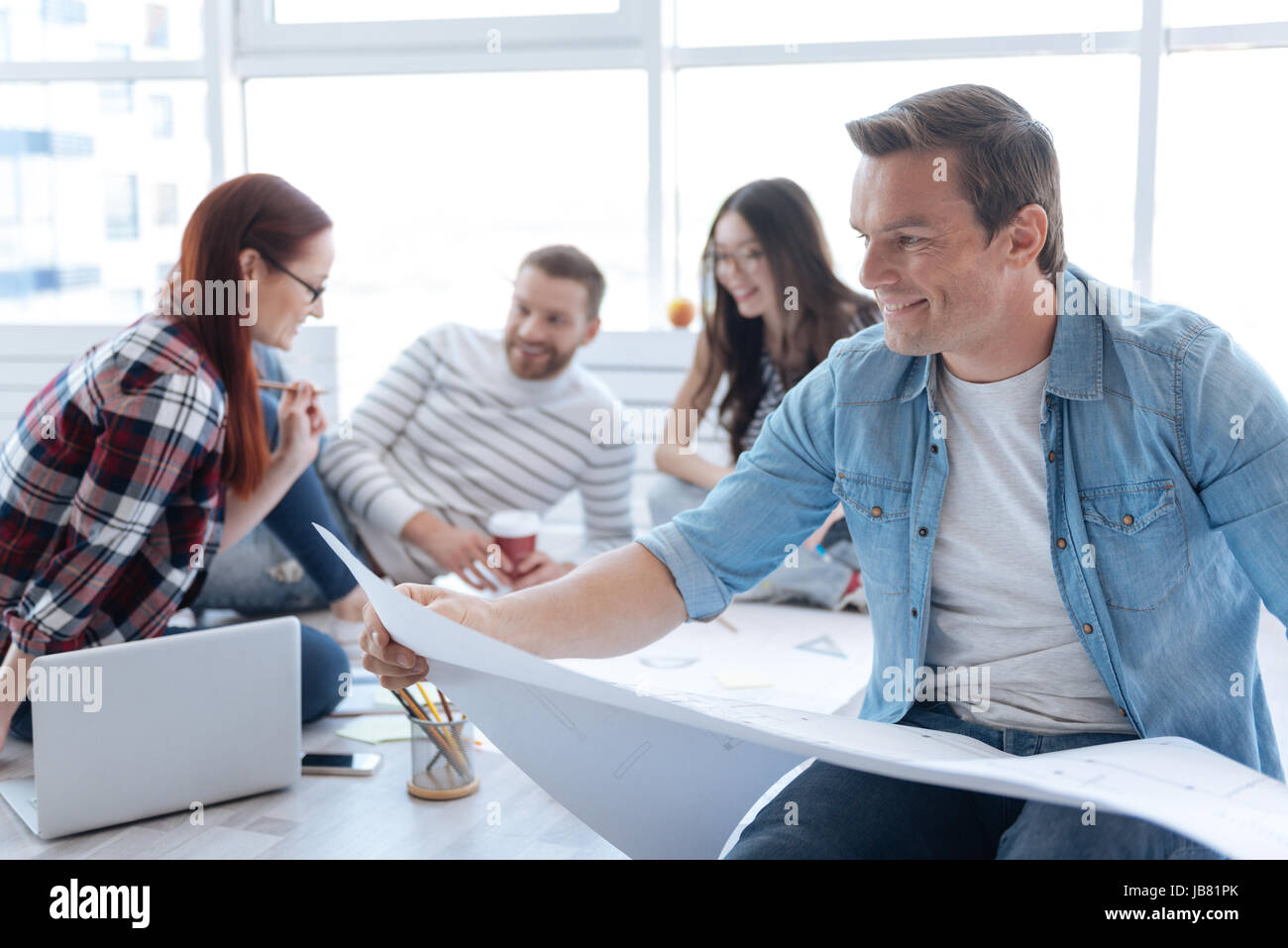 Joyful happy man looking at the drawing Stock Photo - Alamy