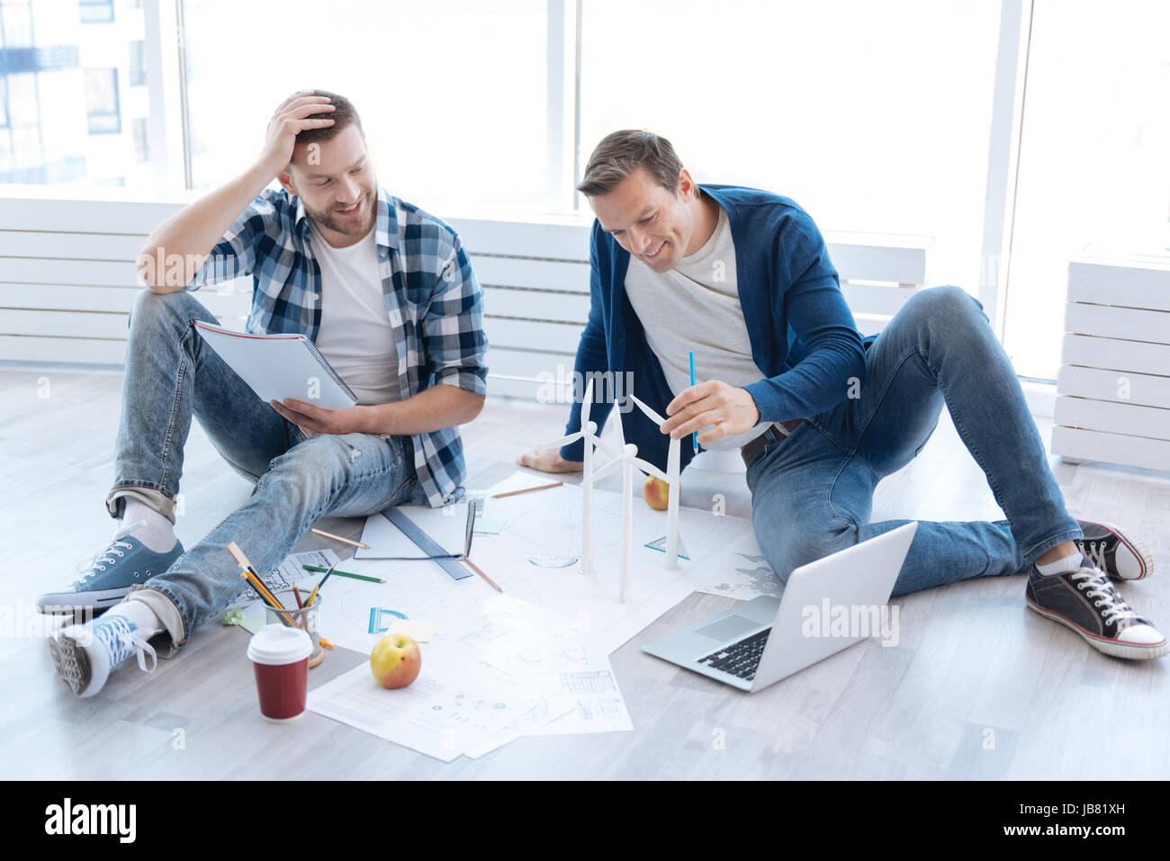 Handsome cheerful man looking at the windmill model Stock Photo - Alamy
