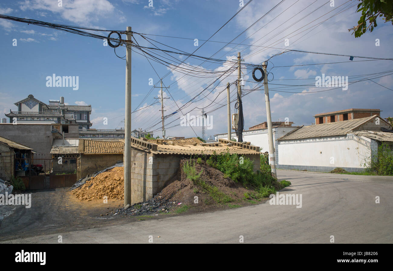 Overhead power cables running across village with depot for sand and ...