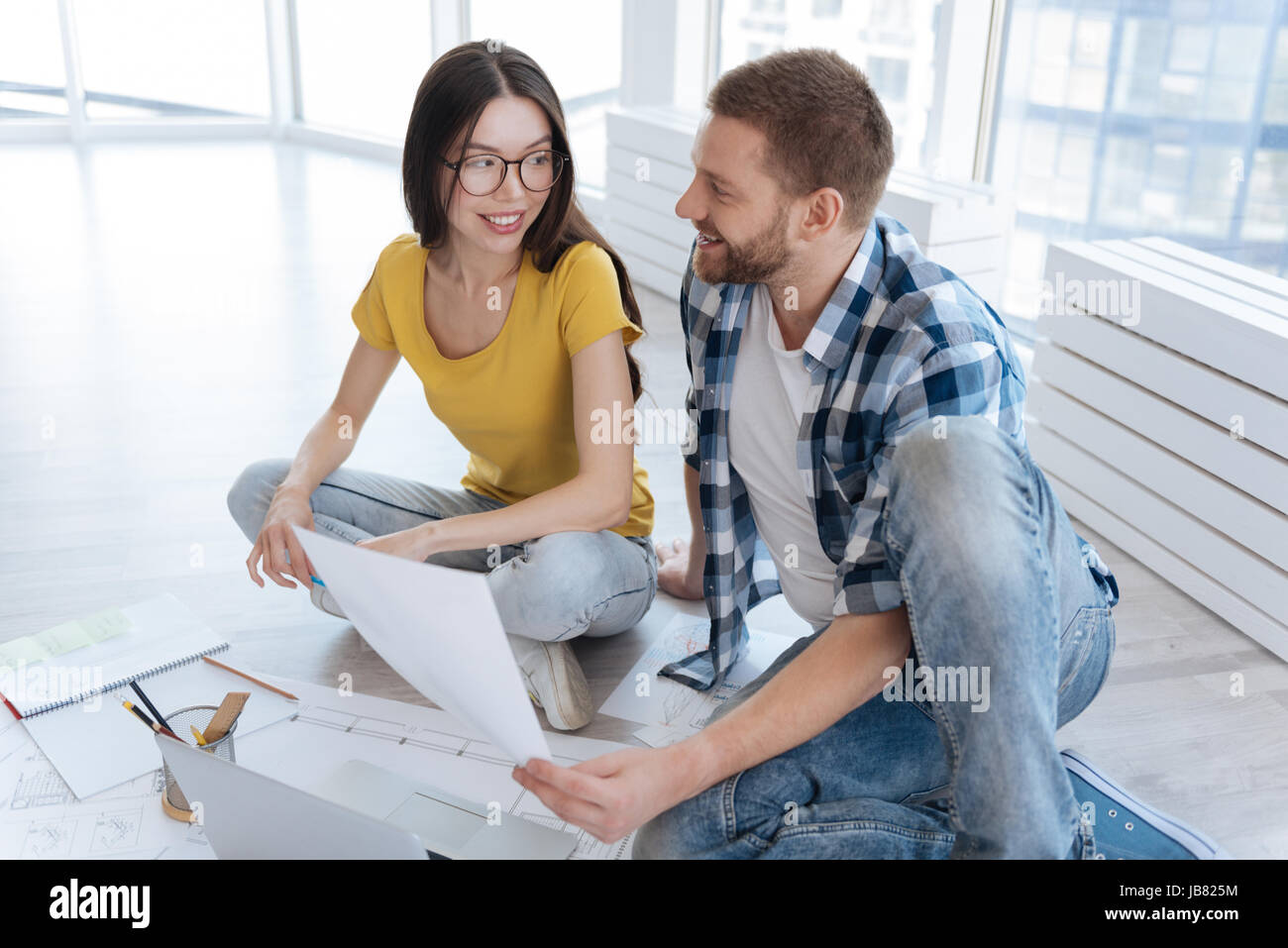 Pleasant nice colleagues looking at each other Stock Photo - Alamy