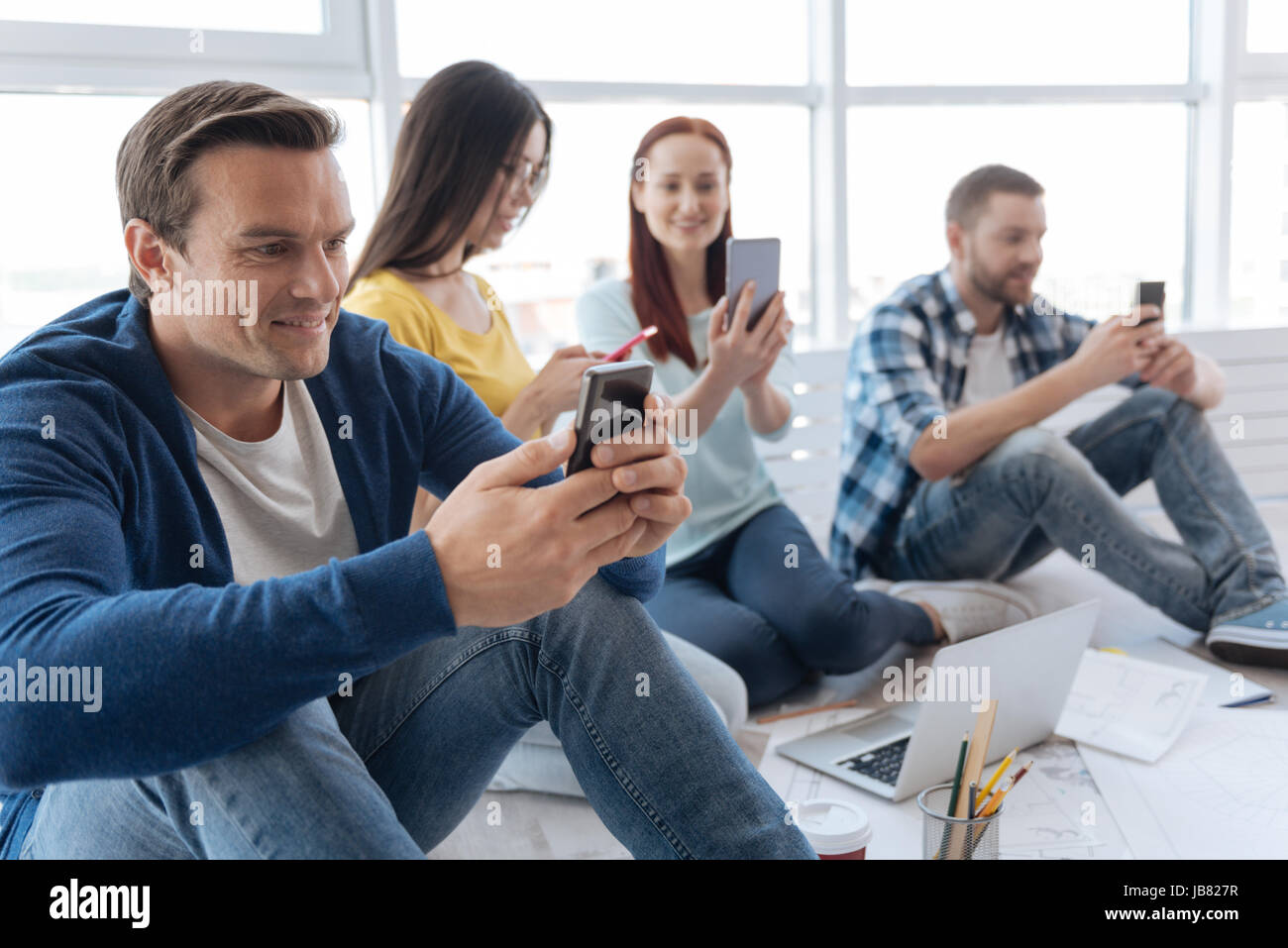 Handsome cheerful man looking at the smartphone screen Stock Photo - Alamy