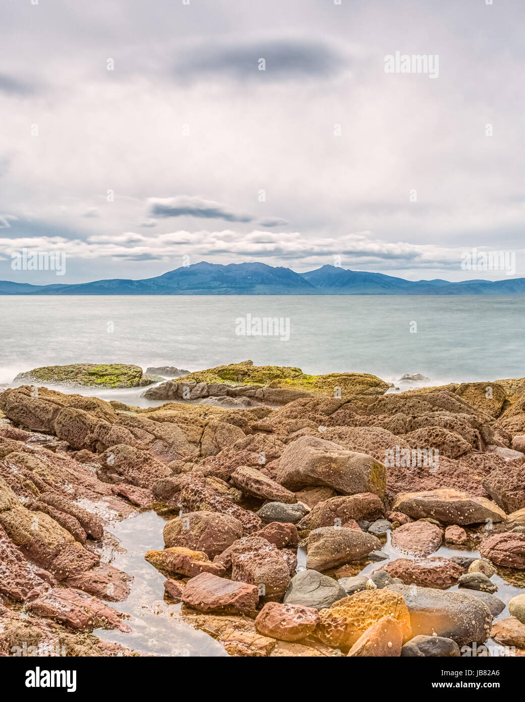 Arran Hills from the shore at Seamill with the honeycomb rocks ...