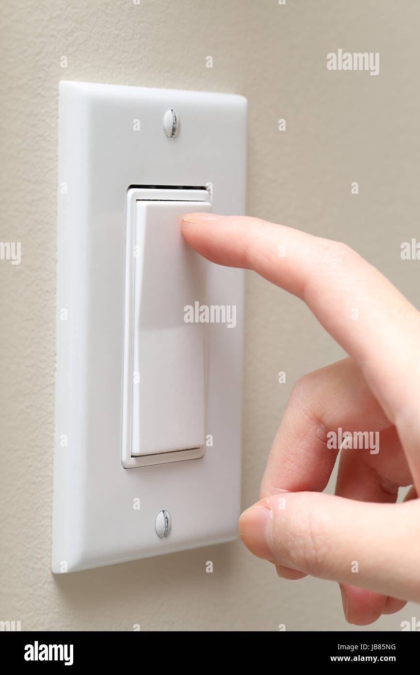 Woman hand turning on the light with a wall switch Stock Photo - Alamy