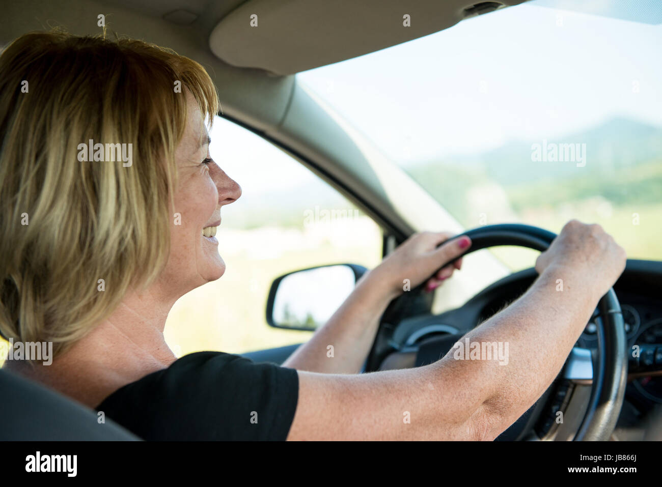 Lifestyle photo of attractive senior woman driving car Stock Photo - Alamy