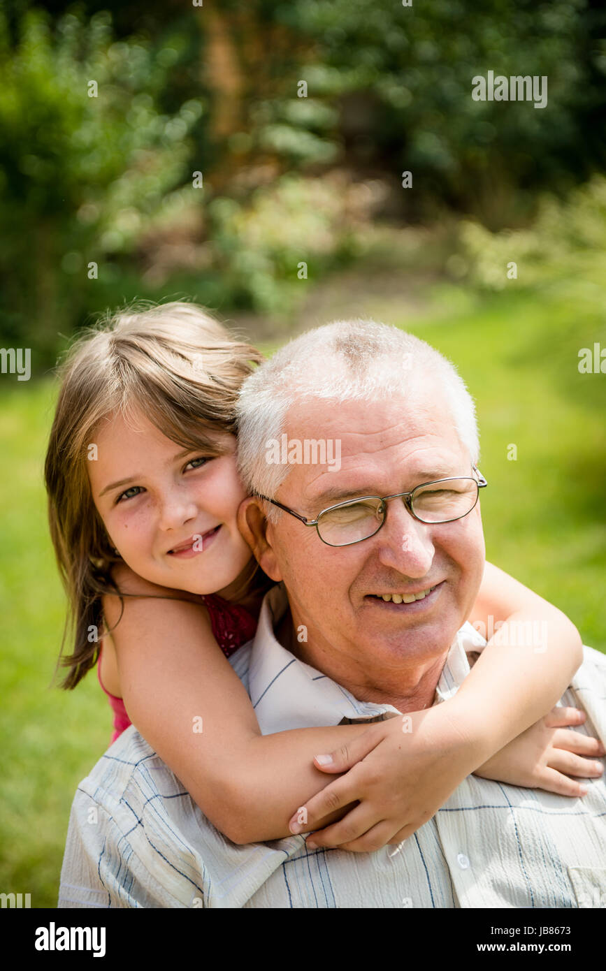 Outdoor lifestyle portrait of grandchild hugging grandfather Stock ...